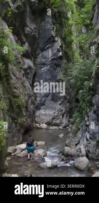 A young man walking canyon river aerial view, nature walks among the ...