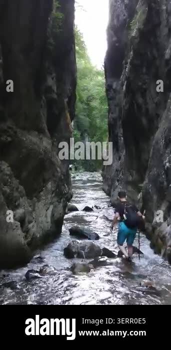 A young man walking canyon river aerial view, nature walks among the ...