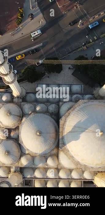 Overhead view of the mosque between the buildings, people are praying ...