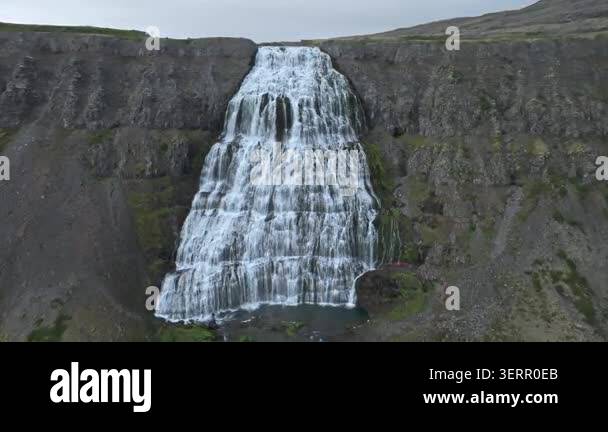 Aerial flight over the beautiful and wide sweeping waterfall Dynjandi ...