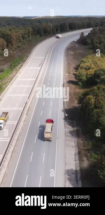 An aerial view of the two sides of a highway surrounded by trees in ...