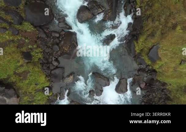 Aerial flight over the river below the Fardagafoss waterfall on a ...