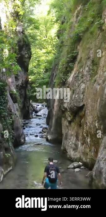 A young man walking canyon river aerial view, nature walks among the ...