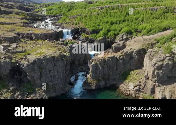 Aerial flight over the wild Nykurhylsfoss (Sveinsstekksfoss) waterfall ...