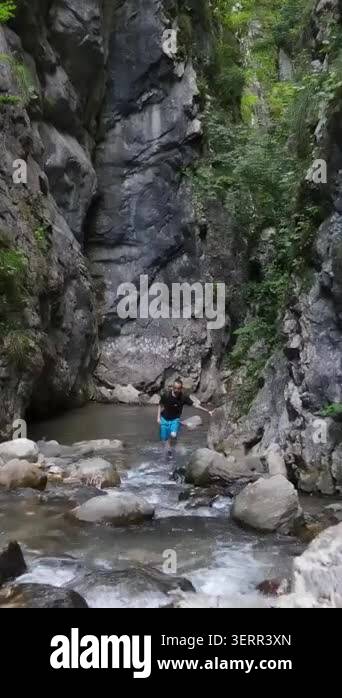 A young man walking canyon river aerial view, nature walks among the ...