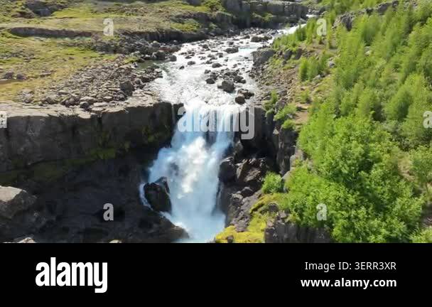 Aerial flight over the wild Nykurhylsfoss (Sveinsstekksfoss) waterfall ...
