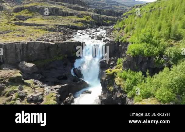Aerial flight over the wild Nykurhylsfoss (Sveinsstekksfoss) waterfall ...