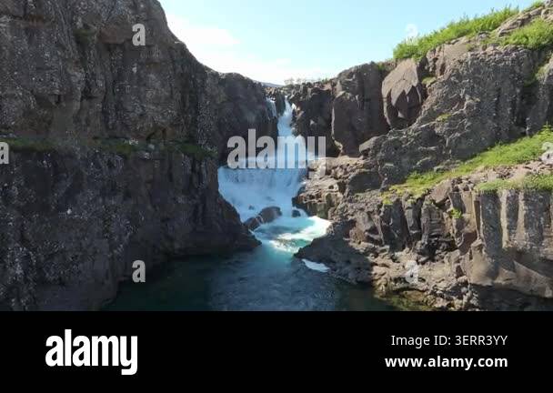 Aerial flight over the wild Nykurhylsfoss (Sveinsstekksfoss) waterfall ...