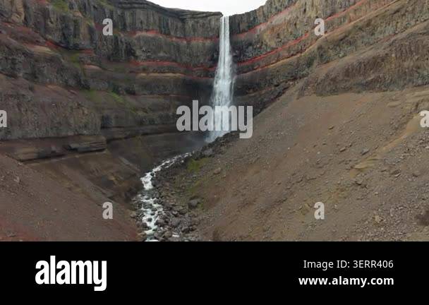 Aerial flight over the famous Hengifoss waterfall on a summer day in ...