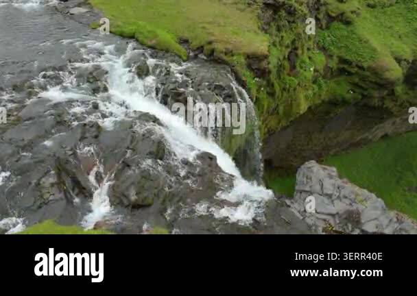 Aerial flight over the beautiful Kvernufoss waterfall on a summer day ...