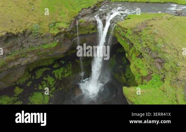 Aerial flight over the beautiful Kvernufoss waterfall on a summer day ...