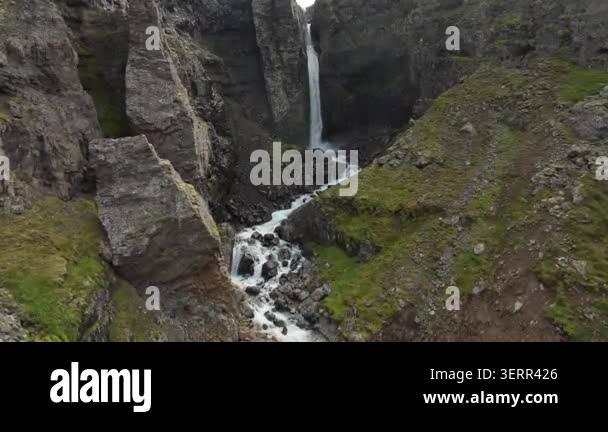 Aerial flight over a nameless waterfall on a summer day located in ...