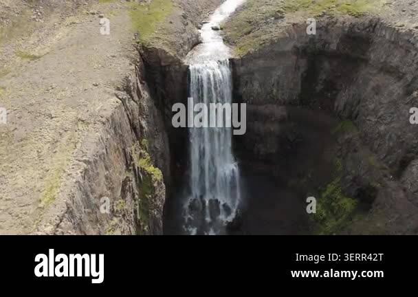Aerial flight over a nameless waterfall on a summer day located in ...