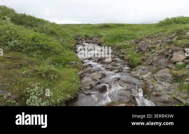Aerial flight over a nameless waterfall on a summer day located in ...