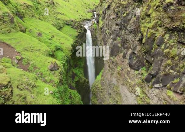 Aerial flight over a wild nameless waterfall at the end of the ...