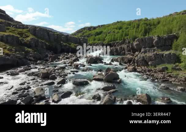 Aerial flight over the streamriver of the wild Nykurhylsfoss ...