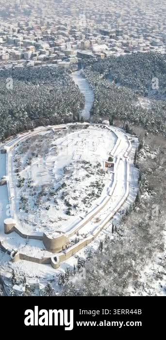 Historical city castle on top of the mountain covered with snow in ...