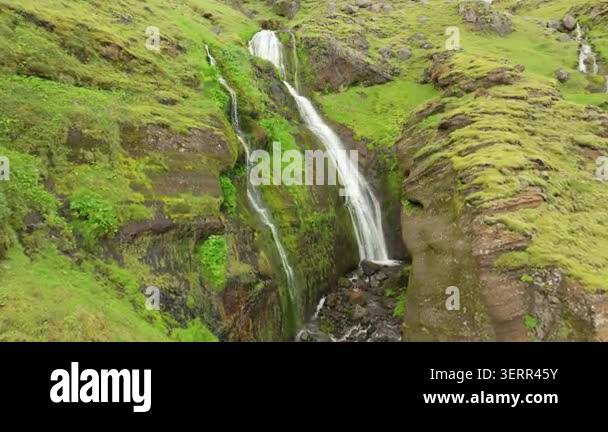 Aerial flight over a wild nameless waterfall at the end of the ...