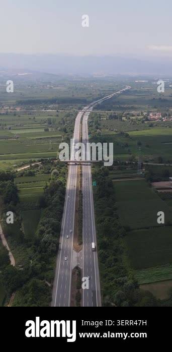 Aerial view of asphalt road with the rural area on both sides, the ...