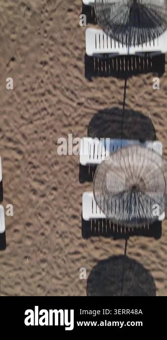 Top-down shot of the beach, showing blue umbrellas in an empty bath ...