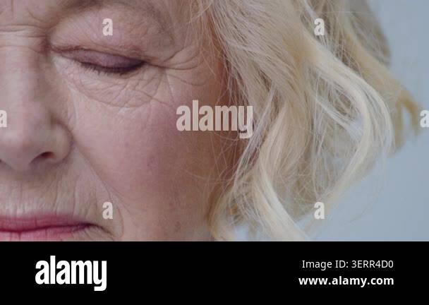 Close-up detail view of beauty senior blonde woman model opening lovely ...