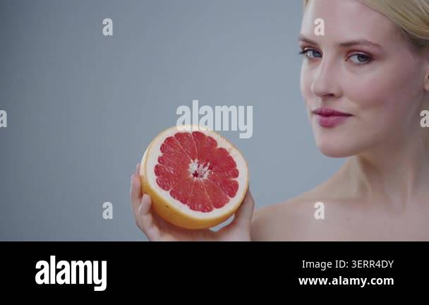 Lovely portrait of natural beauty blonde woman holding a ripe citrus ...