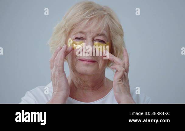 Nice pure portrait of healthy aged woman with blonde hair putting on ...