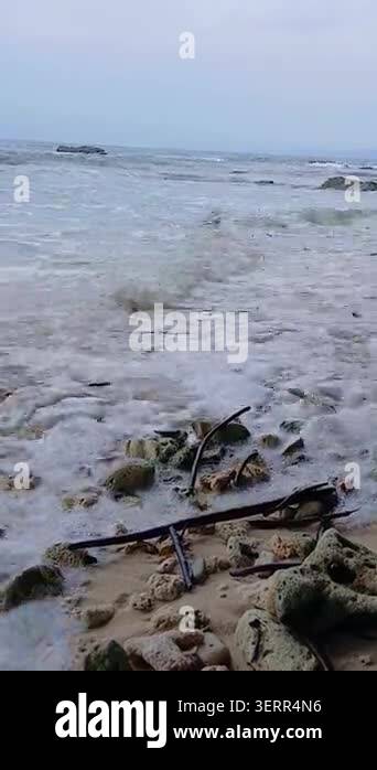 Sea waves and seafoam washing over rocky Radhanagar Beach shore Stock ...