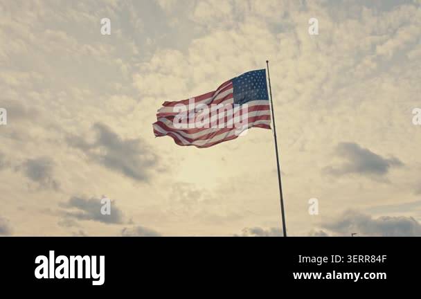National usa flag flying on a flagpole against a cloudy sky with the ...
