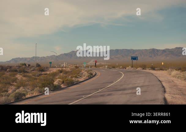 Point of view driving along a winding asphalt road through a desolate ...
