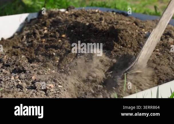 Loosening soil in garden bed with hand hoe in slow motion. High quality ...