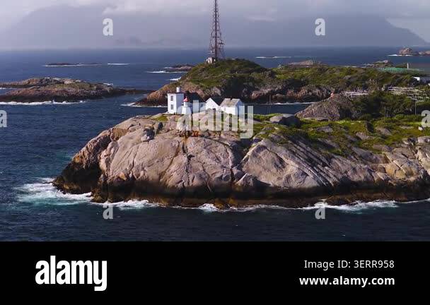 Aerial view of a white lighthouse and keeper houses on granite, a ...