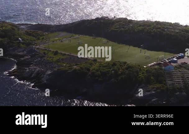 Aerial view of a small turf football pitch on a rocky promontory in ...