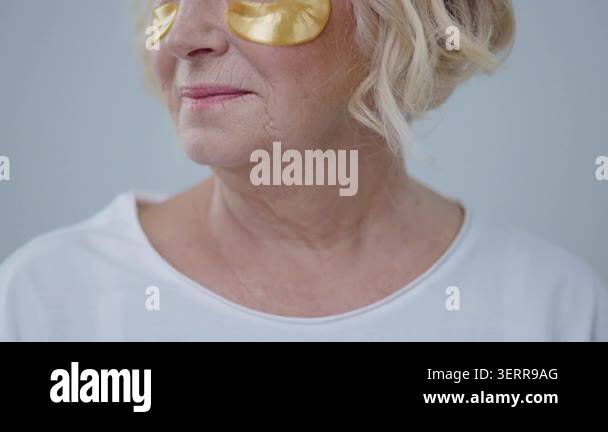 Appealing blonde older woman with blonde hair and golden eye patches on ...
