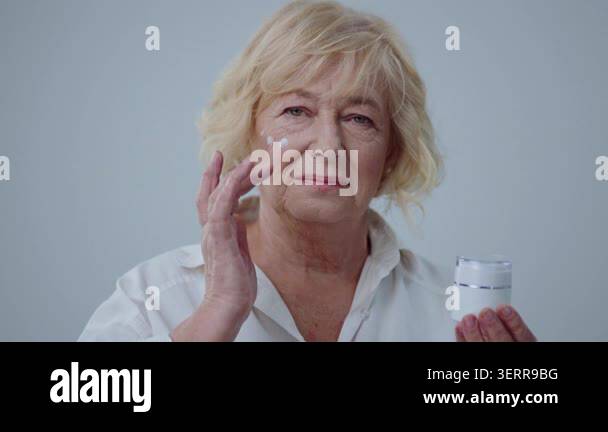Portrait of attractive pure blonde old woman having a jar with face ...