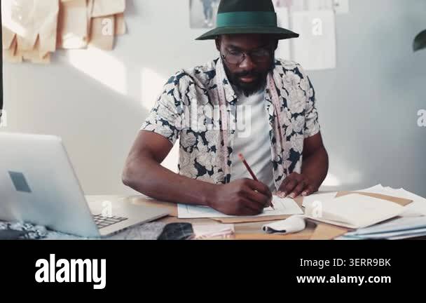 Young talented designer sketching out his new fashion collection, while ...