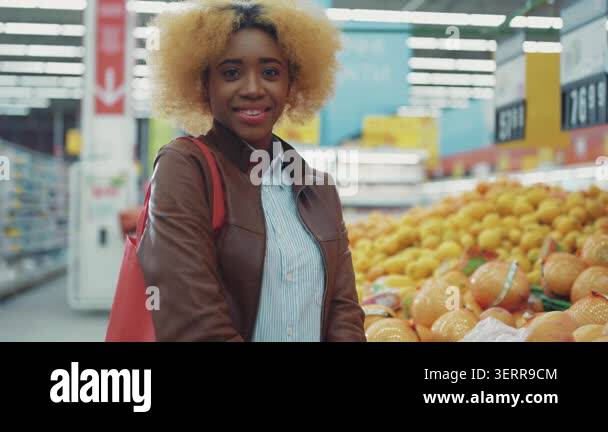 Beautiful african american woman look at camera smile near fruit in ...