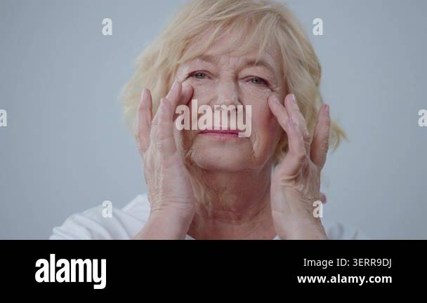 Portrait of pleasant cheerful old lday going an anti-aging massage on ...
