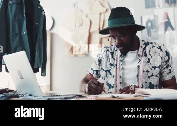 Handsome Afro-American designer studies modern fashion trends via the ...