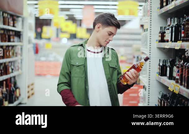 NEW YORK - April 5, 2017: Attractive man choose alcohol in supermarket ...