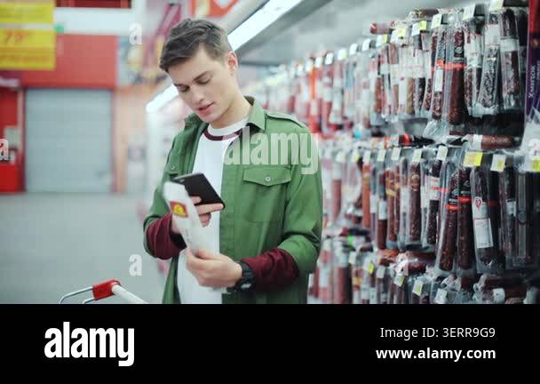 NEW YORK - April 5, 2017: Attractive man use phone chooses ham in the ...