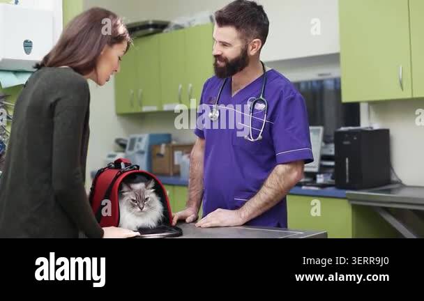 Young good-looking veterinary surgeon and a beautiful girl with dark ...