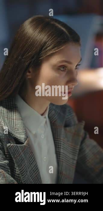 Late night young corporate woman in suit typing computer keyboard ...