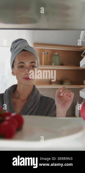 Beautiful caucasian woman in robe opens refrigerator full of healthy ...