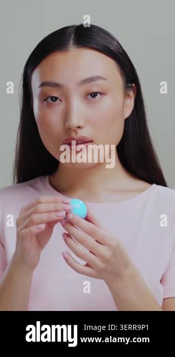 Portrait of beautiful asian woman with gentle shiny skin applying ...