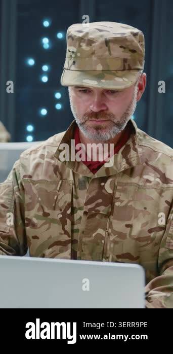 Army soldier in camouflage using laptop computer performing webhosting ...