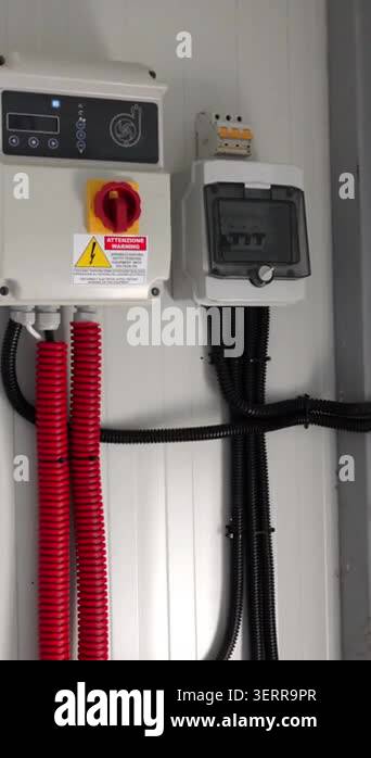Electrical control panel features red cables and black wiring ...