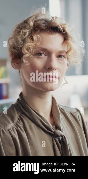 Close-up portrait of calm nice female office worker with blonde curly ...