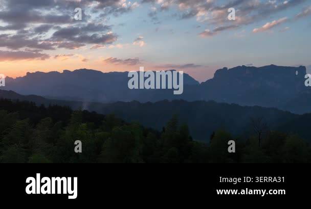 Time lapse of a dramatic mountain range at sunset with clouds and sun ...