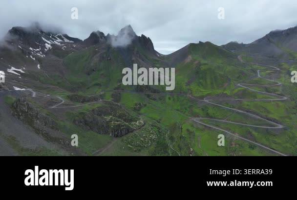 Aerial drone footage of a winding mountain road with sharp switchbacks ...